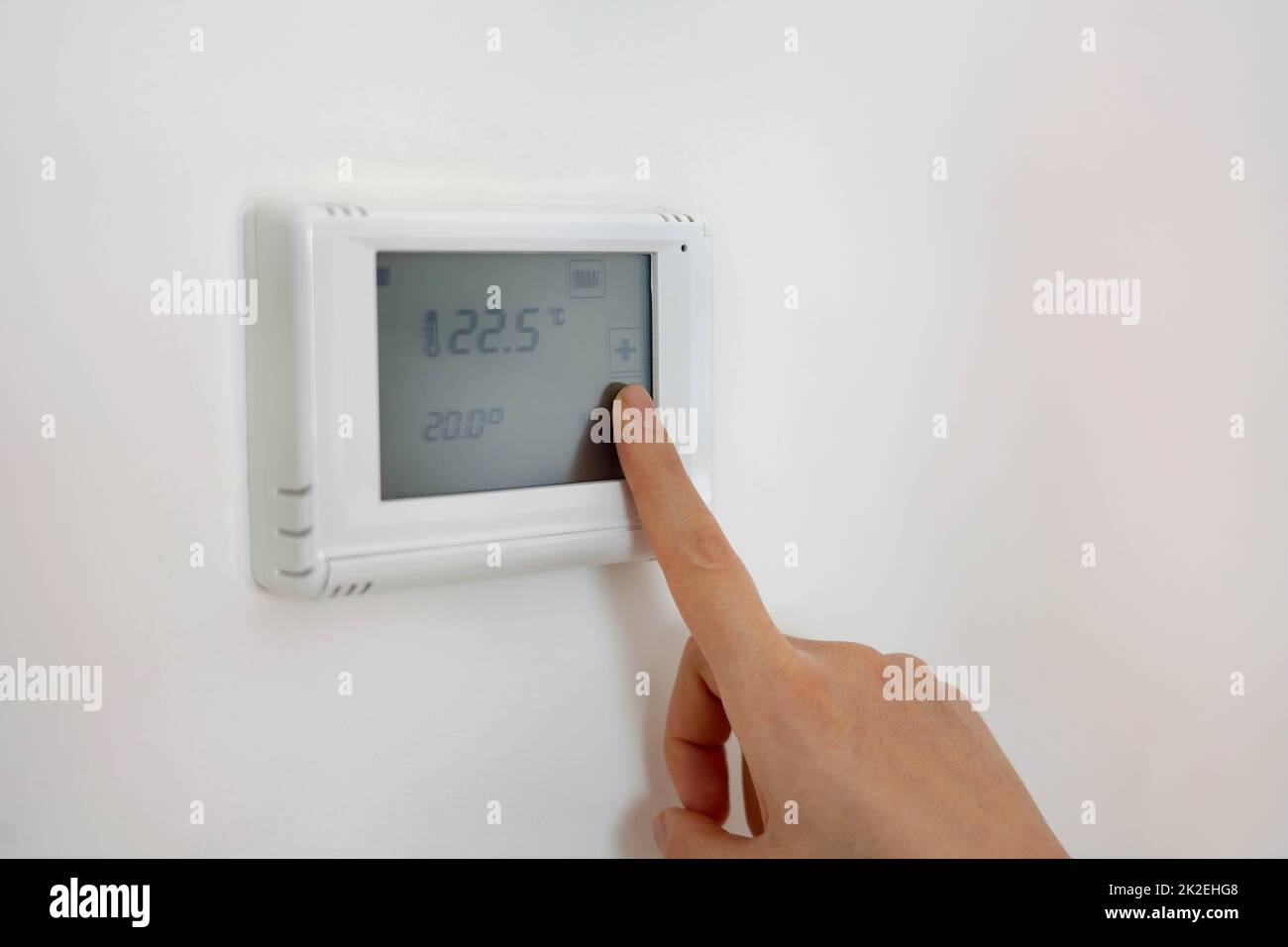 Lowering the temperature for energy saving. Human hand adjusting ...