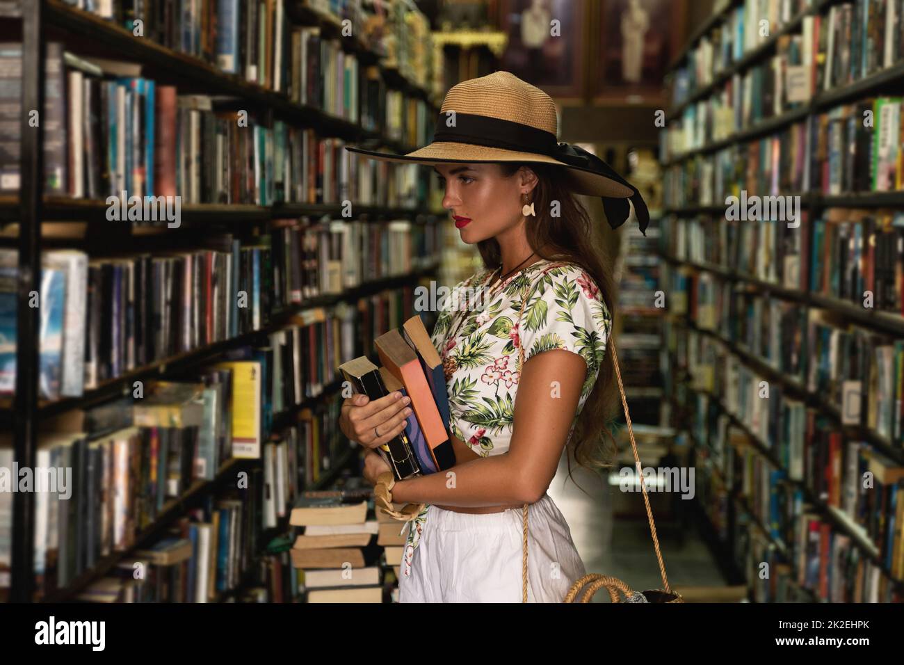 Beautiful girl wearing stylish outfit looking for interesting book in ...