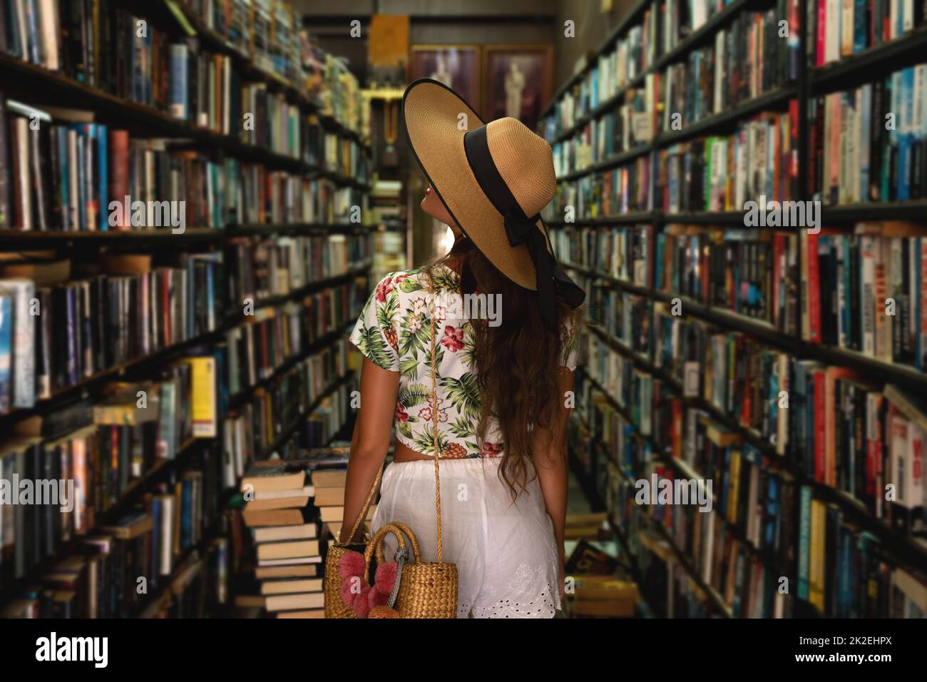 Beautiful girl wearing stylish outfit looking for interesting book in ...