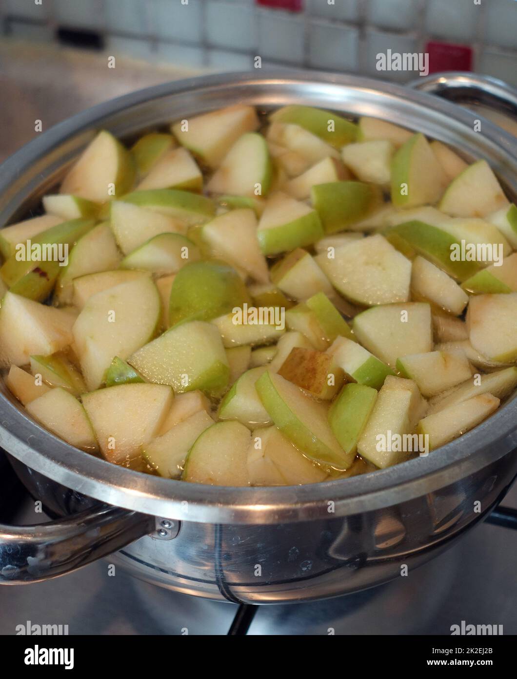 freshly chopped green sour apple pieces boiling in pot,make homemade ...