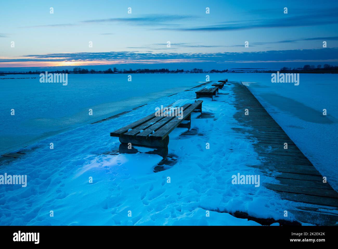 Wooden pier with benches and a snow-covered lake Stock Photo - Alamy