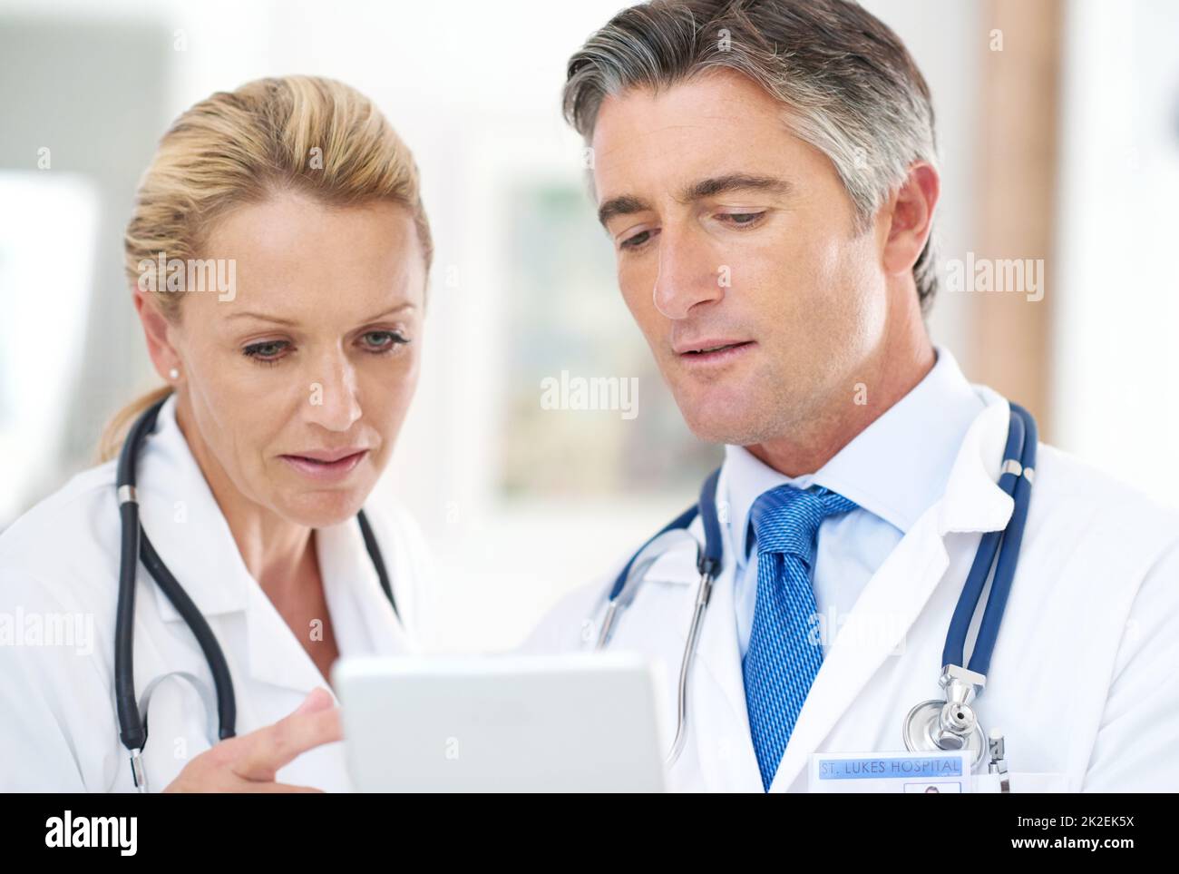 Discussing the diagnosis. Shot of two doctors talking together over a ...