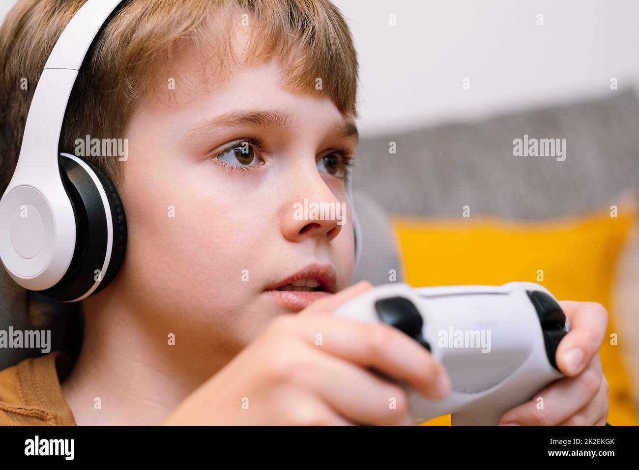 Portrait of concentrated teen boy with a joystick in his hands playing ...