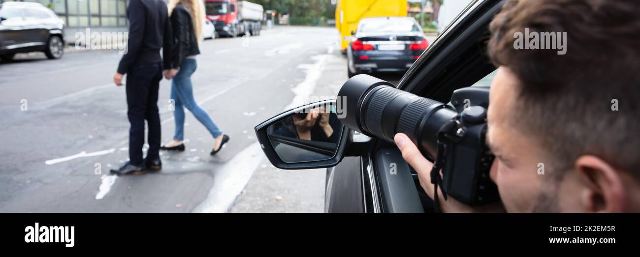 Male Spy Taking Photograph Of A Couple Walking On Street Stock Photo ...
