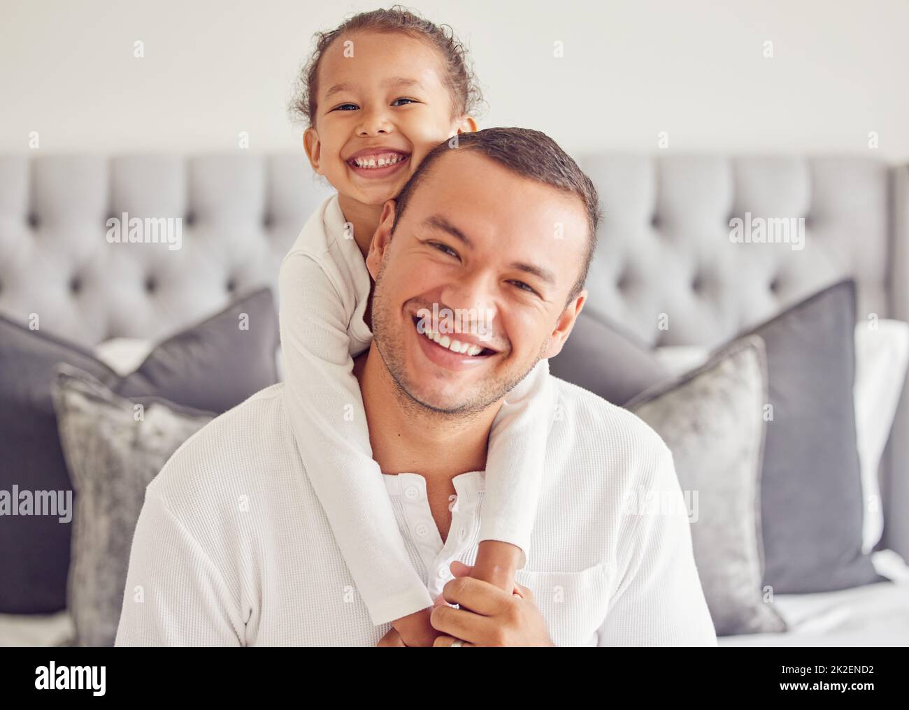 Children, family and love with a man and his girl sitting on a bed in ...