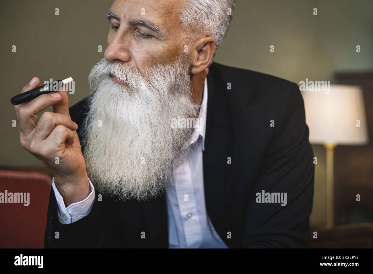 Handsome senior man smoking tobacco heating system Stock Photo - Alamy