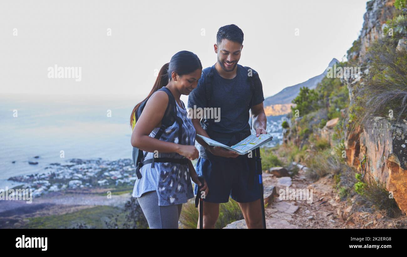 This is so helpful to plot out our hike path. Shot of a young couple ... This is so helpful to plot out our hike path. Shot of a young couple ...