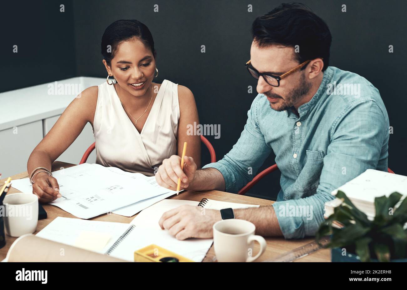They work well together. Cropped shot of two young architects working ...