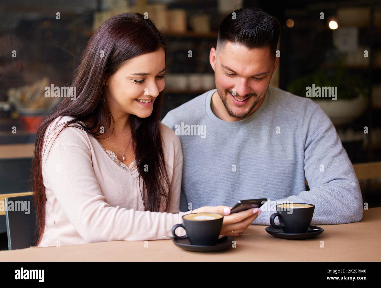 Lets use this code for a discount. Shot of a woman showing showing her boyfriend something on ...