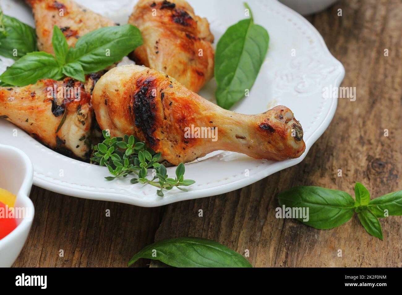 Grilled chicken legs with rosemary served on white plate. Dinner ...