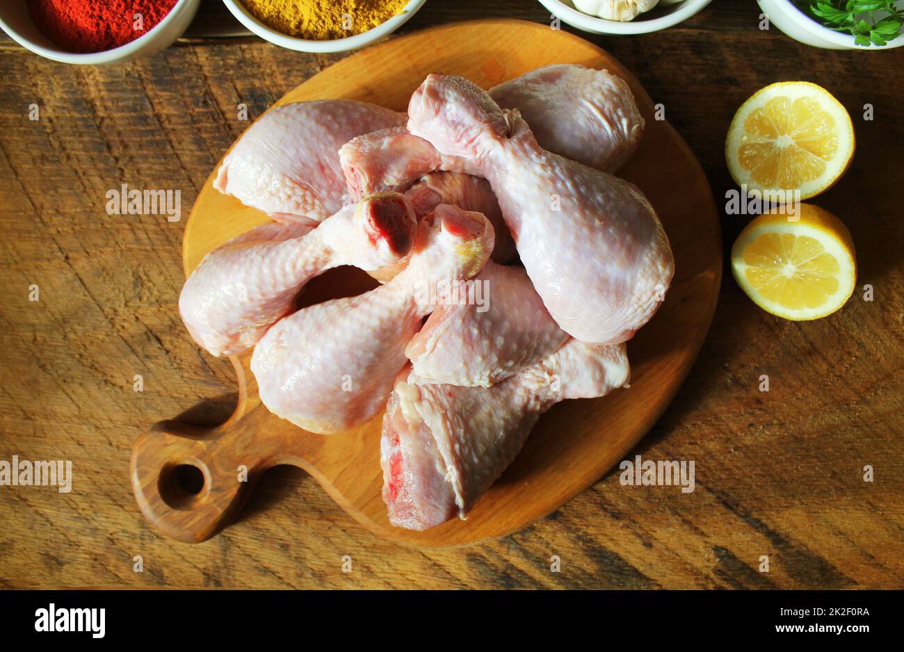 Raw uncooked chicken legs, drumsticks on cutting board, meat with ...