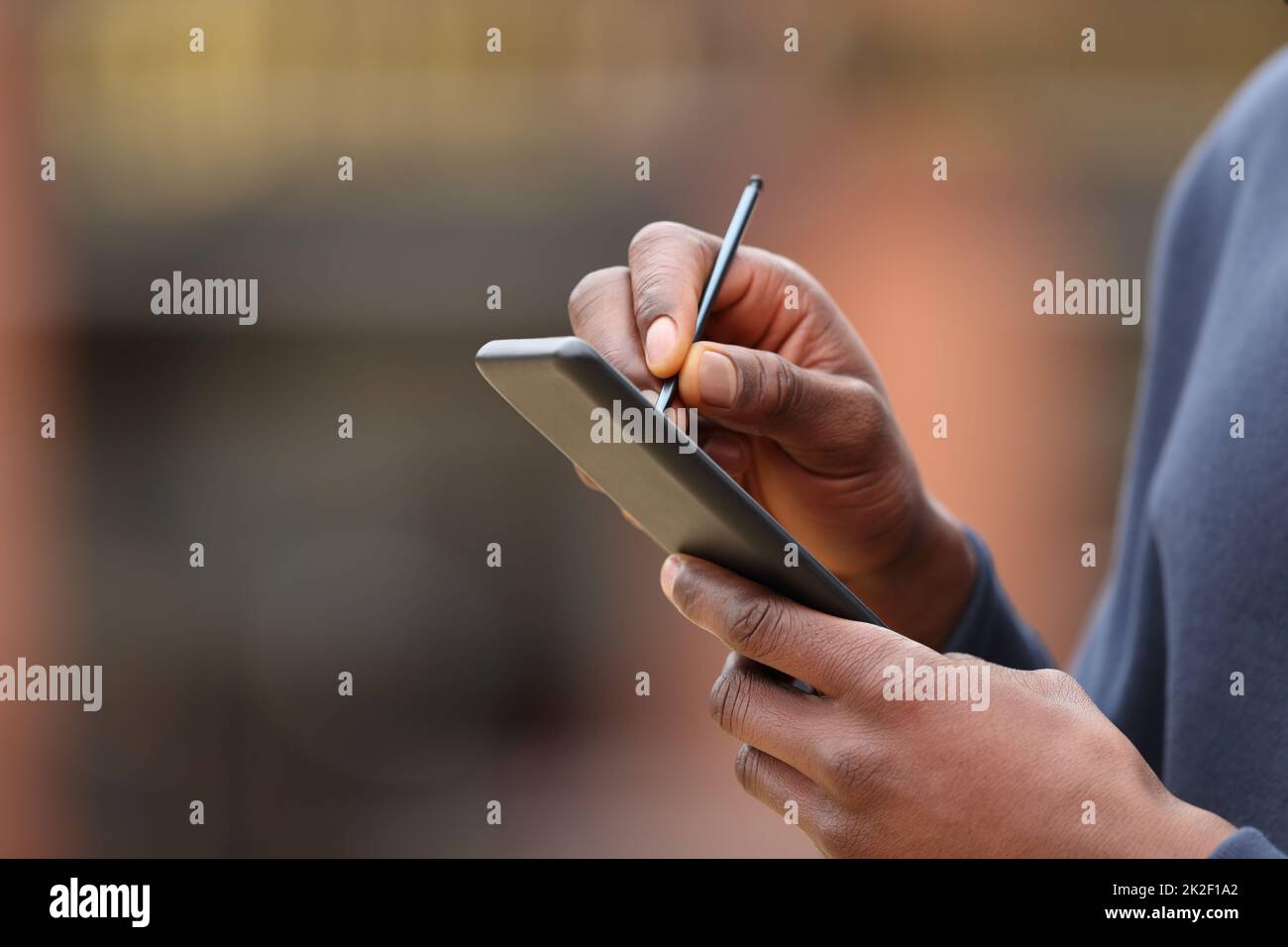 Man with black skin hands using pen on phone Stock Photo - Alamy