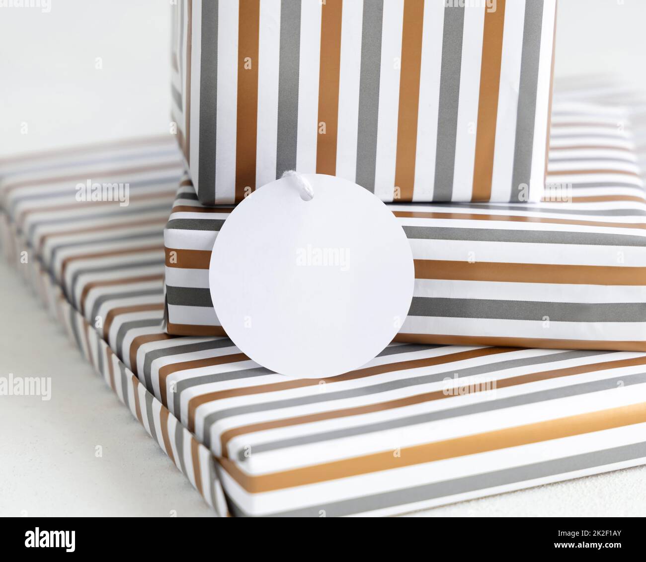 Presents Wrapped in striped paper with blank gift tag close up, label ...