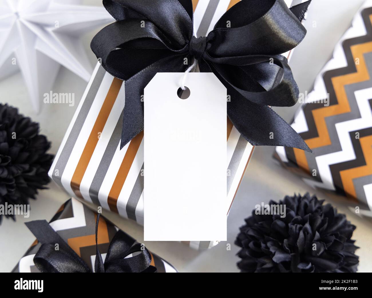 Wrapped present with vertical blank gift tag and black bow close up ...
