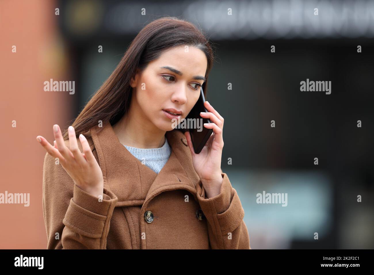Angry woman in the street talking on phone Stock Photo - Alamy