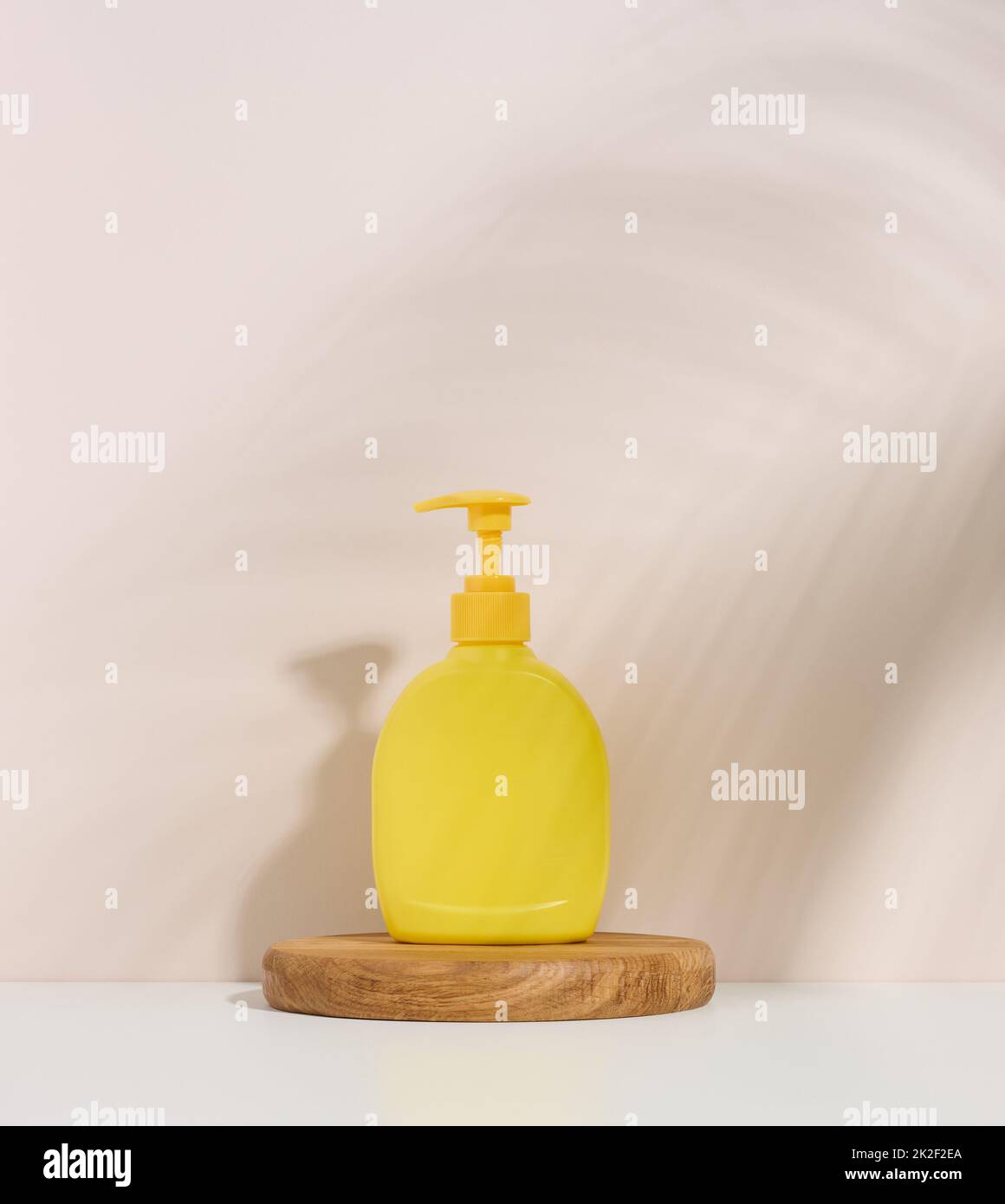 Yellow plastic container with a dispenser on a beige background. Yellow ...