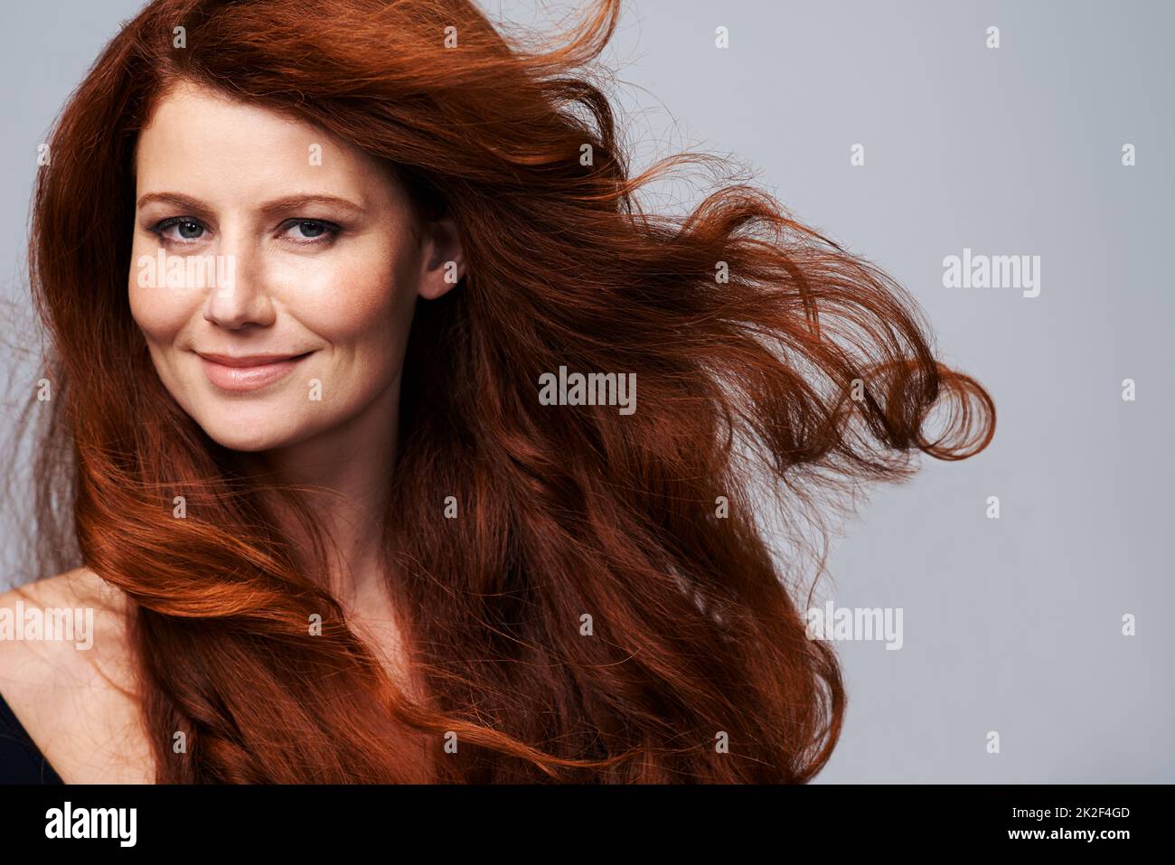 Showing off her crowning glory. Studio shot of a young woman with ...