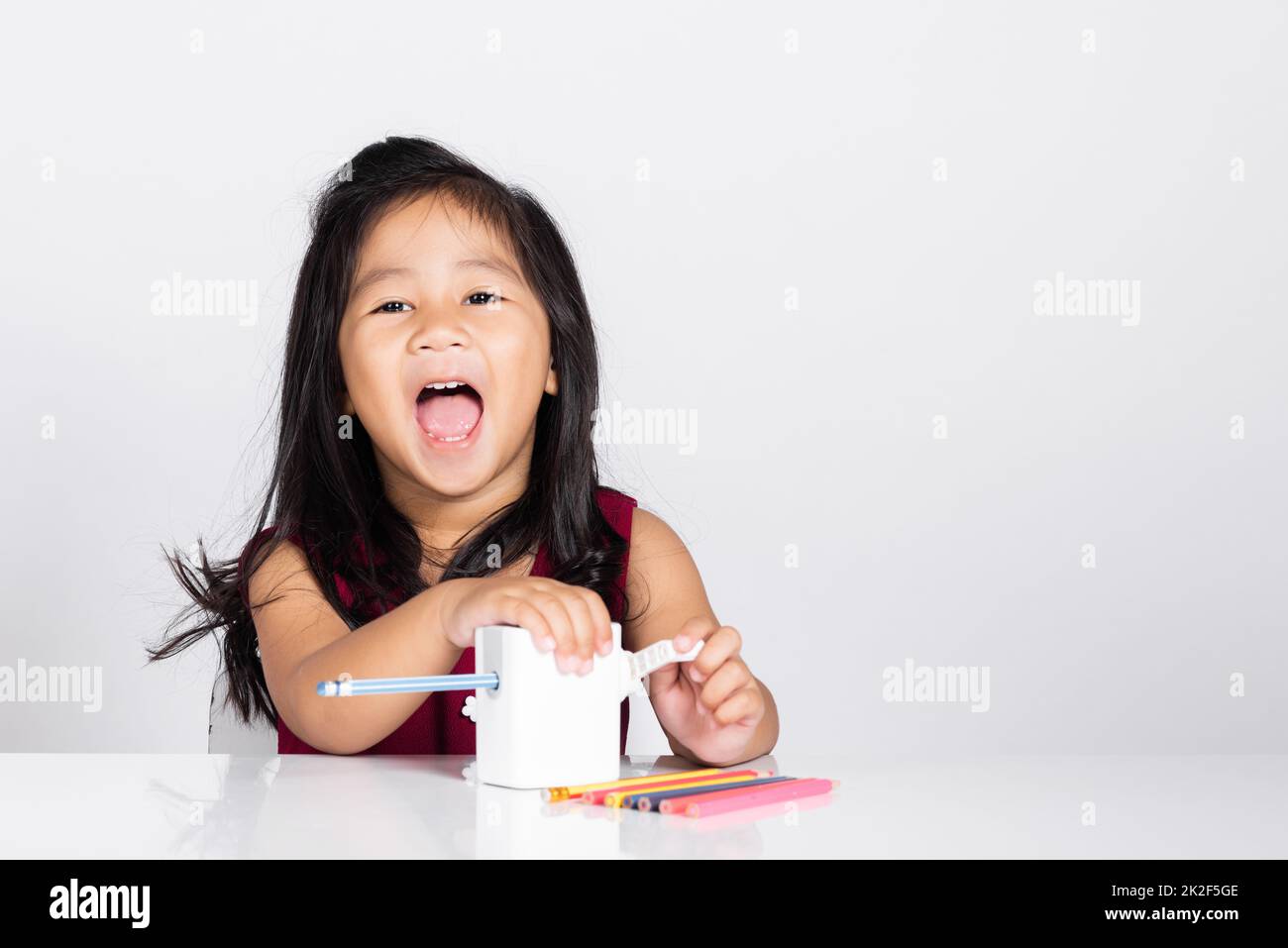 Little cute kid girl 3-4 years old smile using pencil sharpener while ...