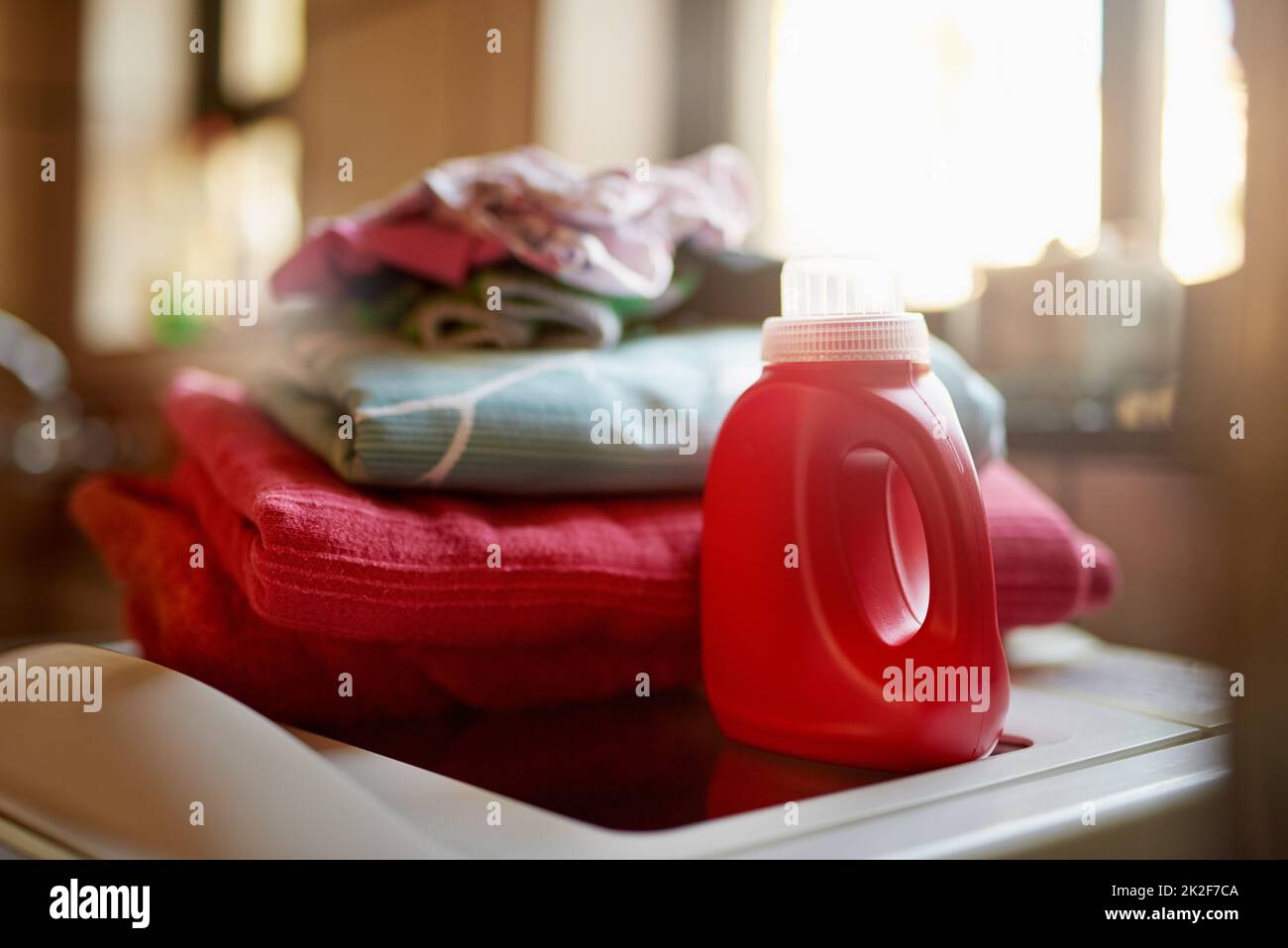 Keeping your laundry clean. Shot of a bottle of detergent and a pile of ...