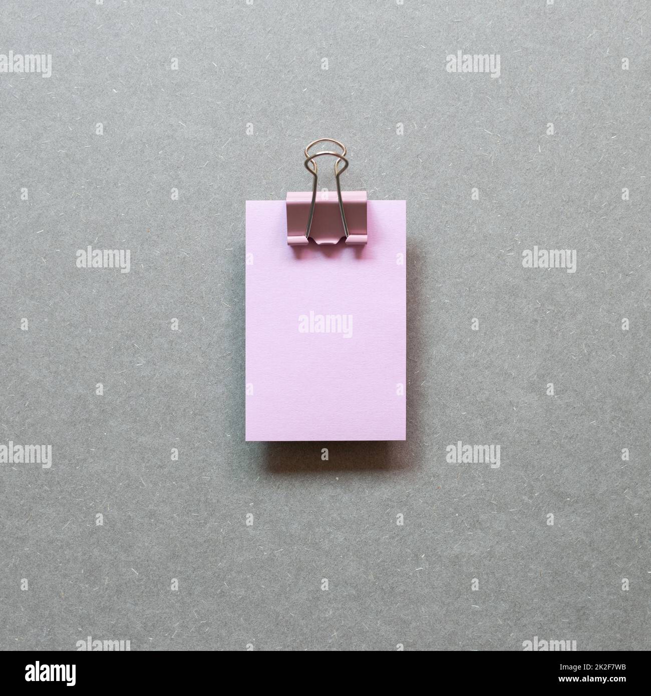 Pink memo paper, sticky notes with binder clip on gray background. top ...