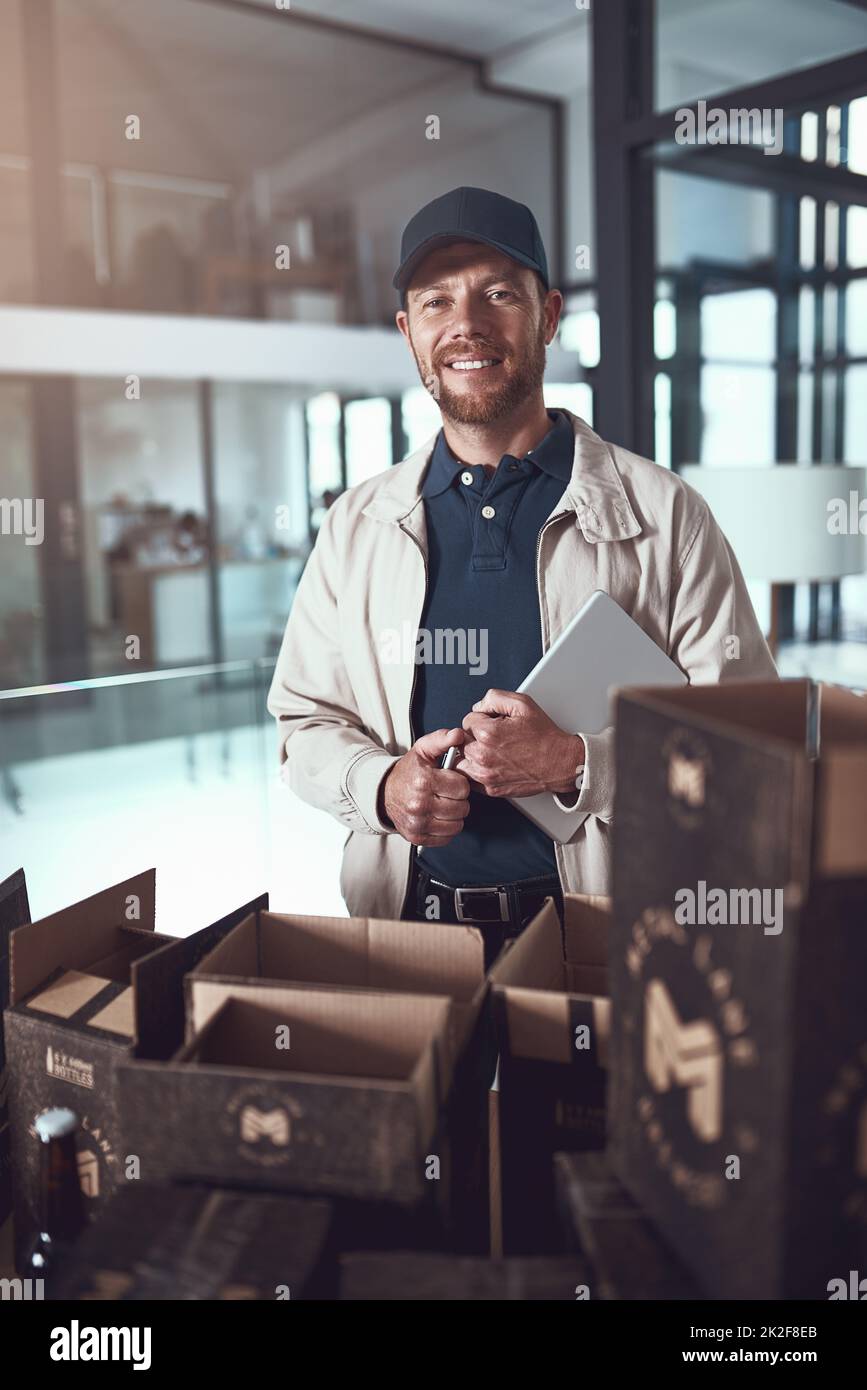 Boxes are part of my life. Portrait of a cheerful young man packing ...