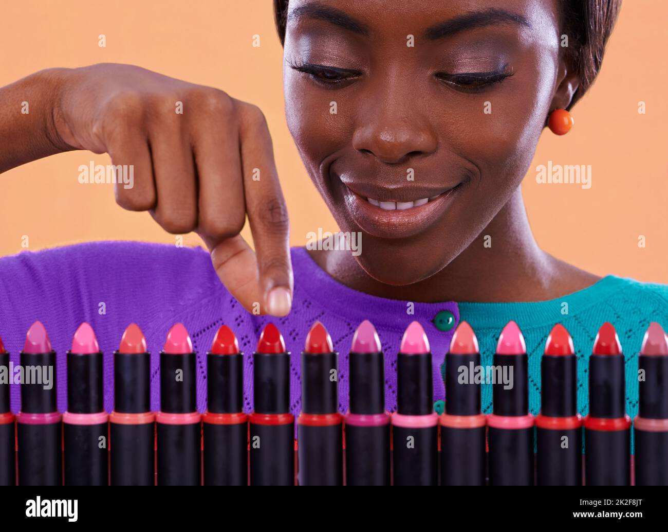 Choosing her color. A young african woman looking over a row of ...