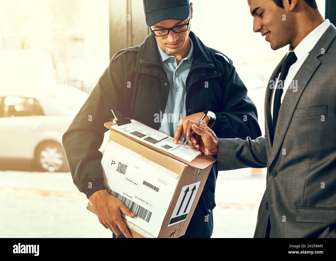 Please mark your name here. Shot of a businessman signing for his ...