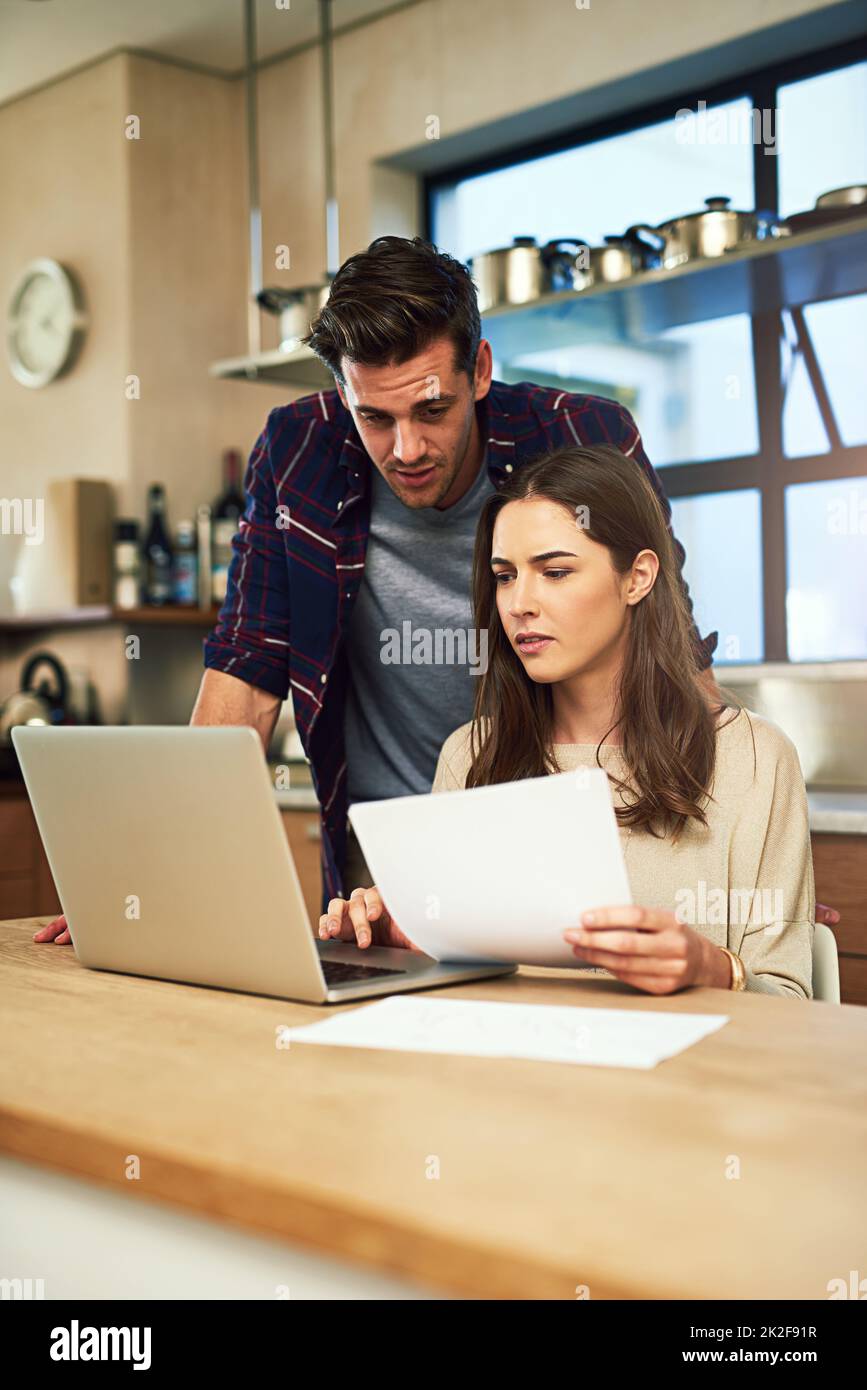 Planning their monthly budget together. Cropped shot of a young couple ...