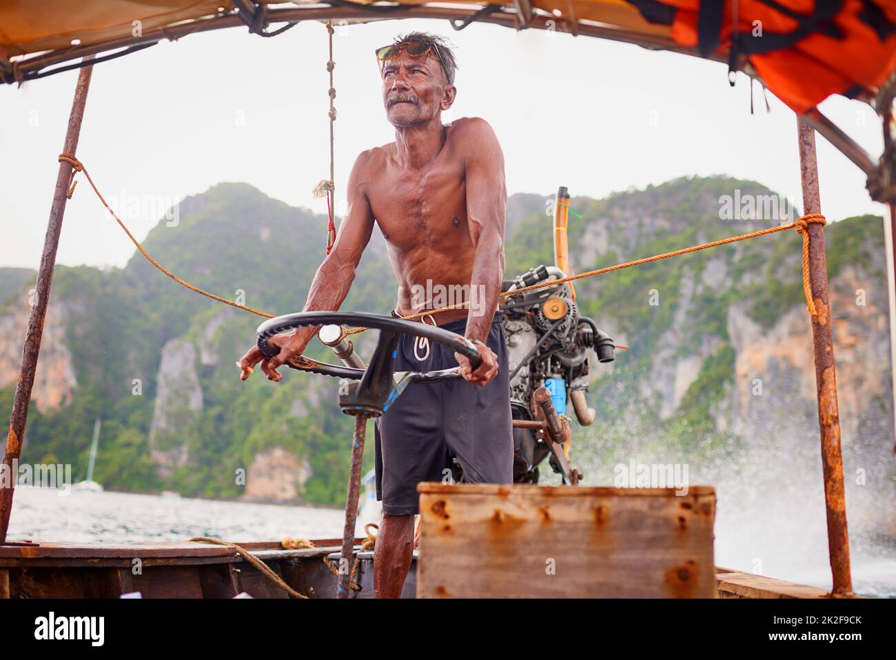 Putting out to sea. Shot of a Thai man operating his tourist boat Stock ...