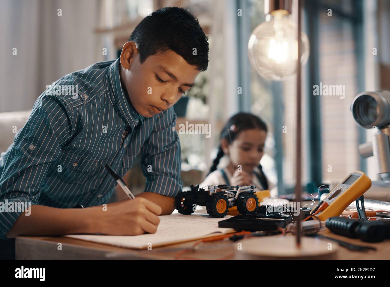 Homework first, playtime after. Shot of a handsome young boy doing his ...