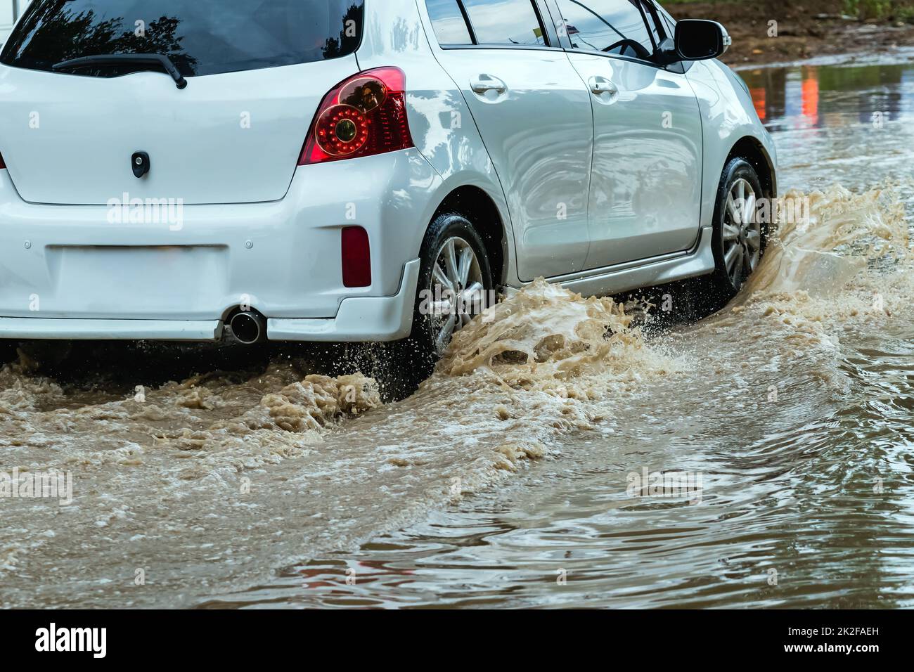 Car passing through a flooded road. Driving car on flooded road during ...