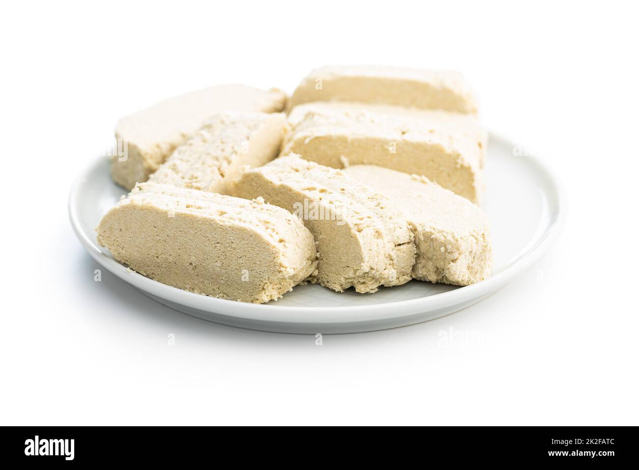 Sweet tahini halva on plate. Turkish dessert isolated on white background Stock Photo - Alamy