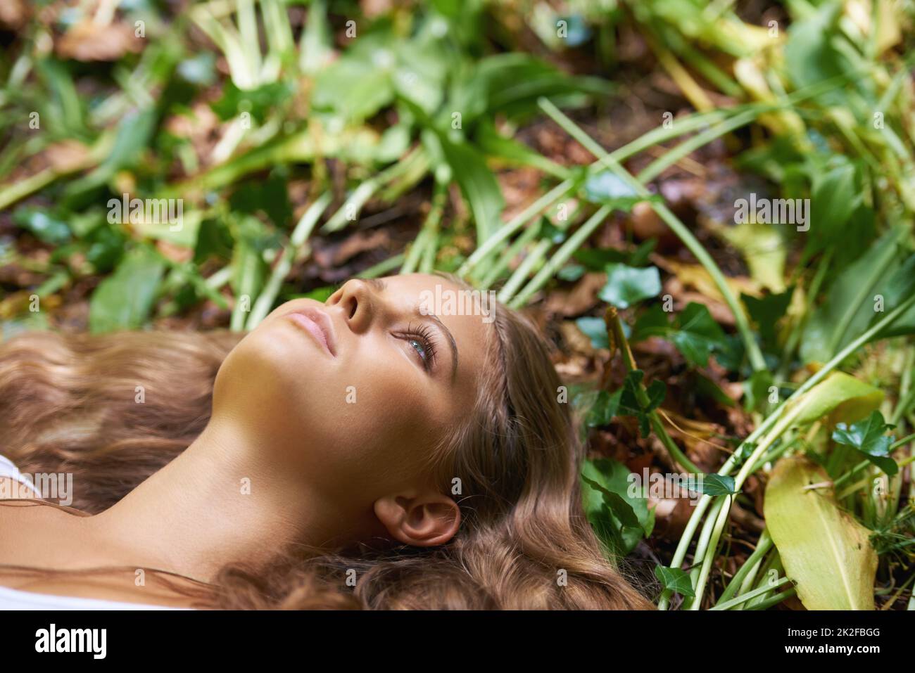 Getting back to nature. A beautiful young woman lying on the forest floor Stock Photo - Alamy