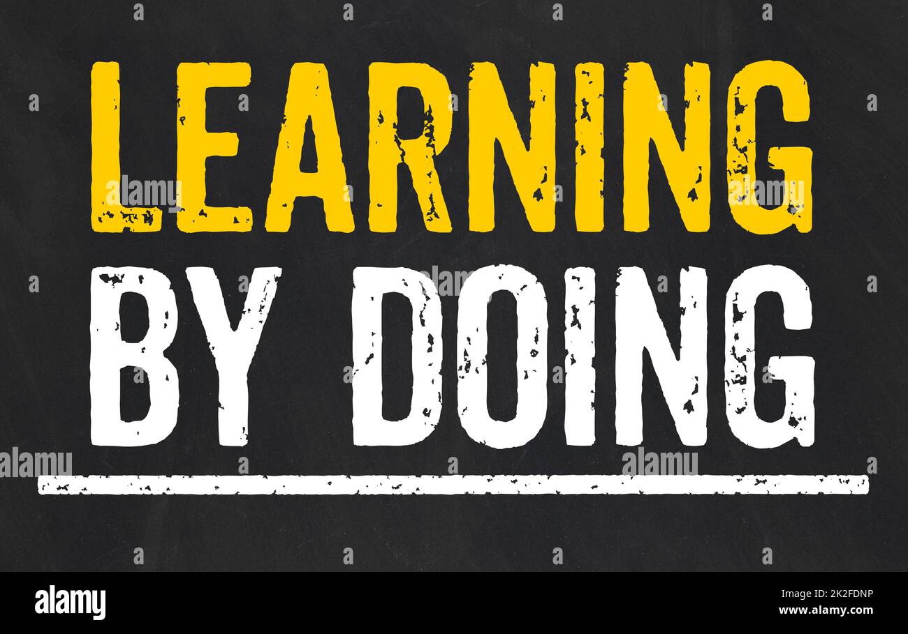 Blackboard with the text Learning by doing Stock Photo - Alamy