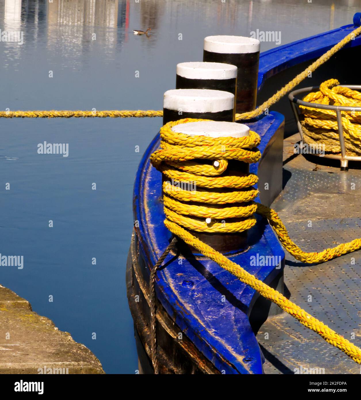 Rope of a ship tied in 3 symmetric directions, part of a blue old boat ...