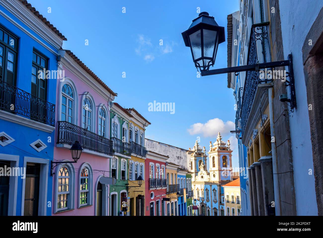 Colorful colonial-style houses and a tower of an old baroque church in ...