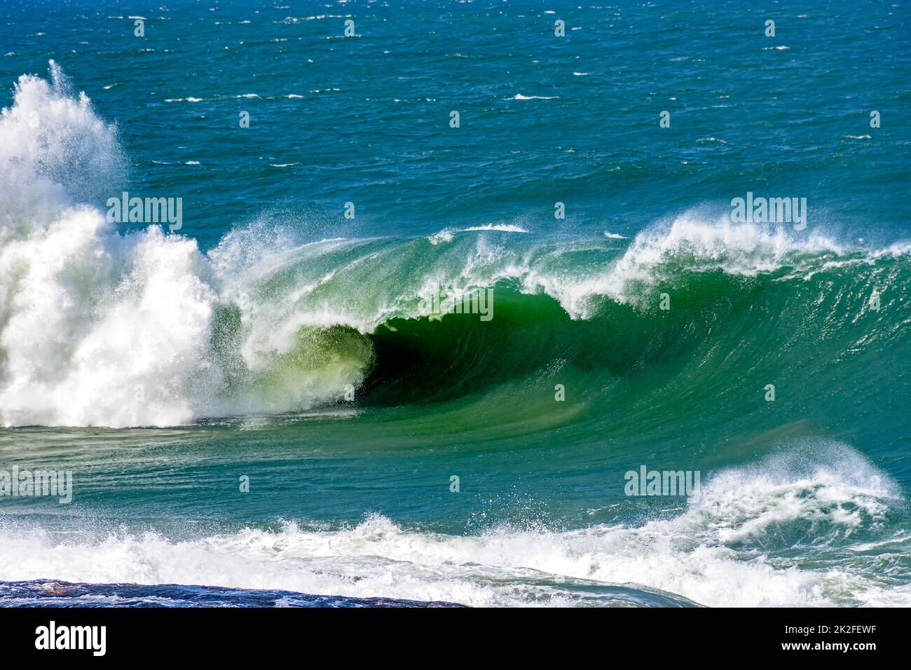 Wave breaking hard in the sea waters Stock Photo - Alamy