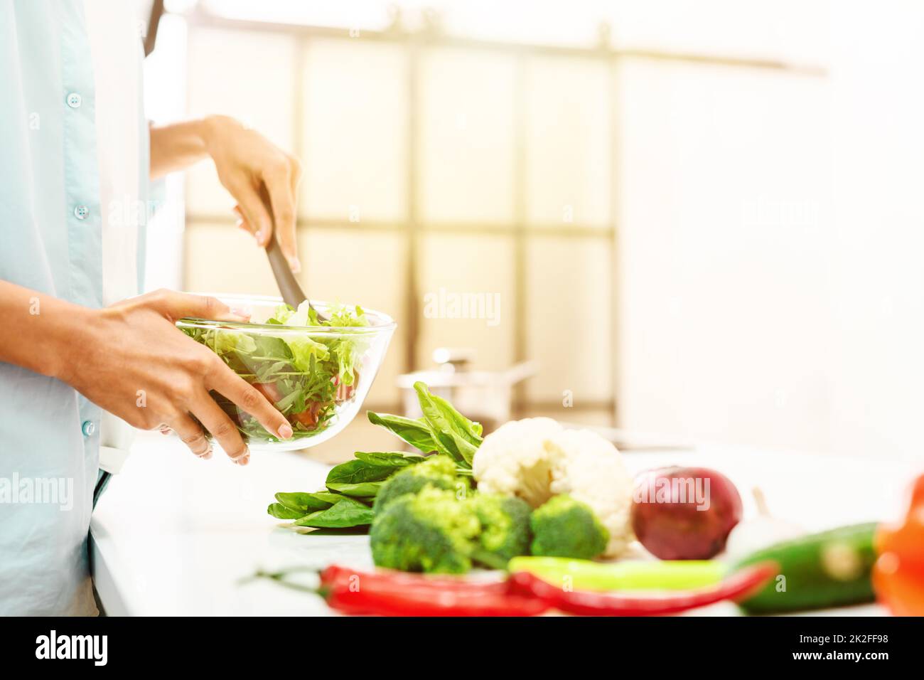 Young Woman In The Home Kitchen Prepares A Genuine Salad With Fresh