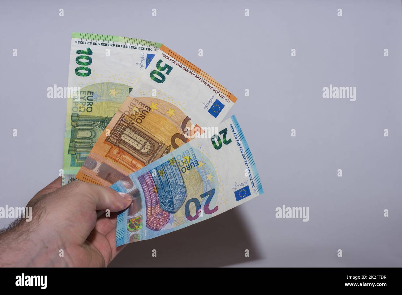 three euro bank notes held up in one hand with gray Stock Photo - Alamy
