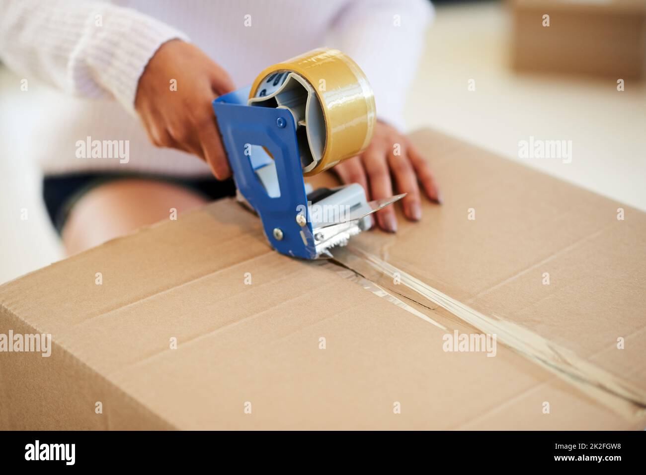 Safe and sealed. Shot of an unidentifiable young woman packing boxes ...