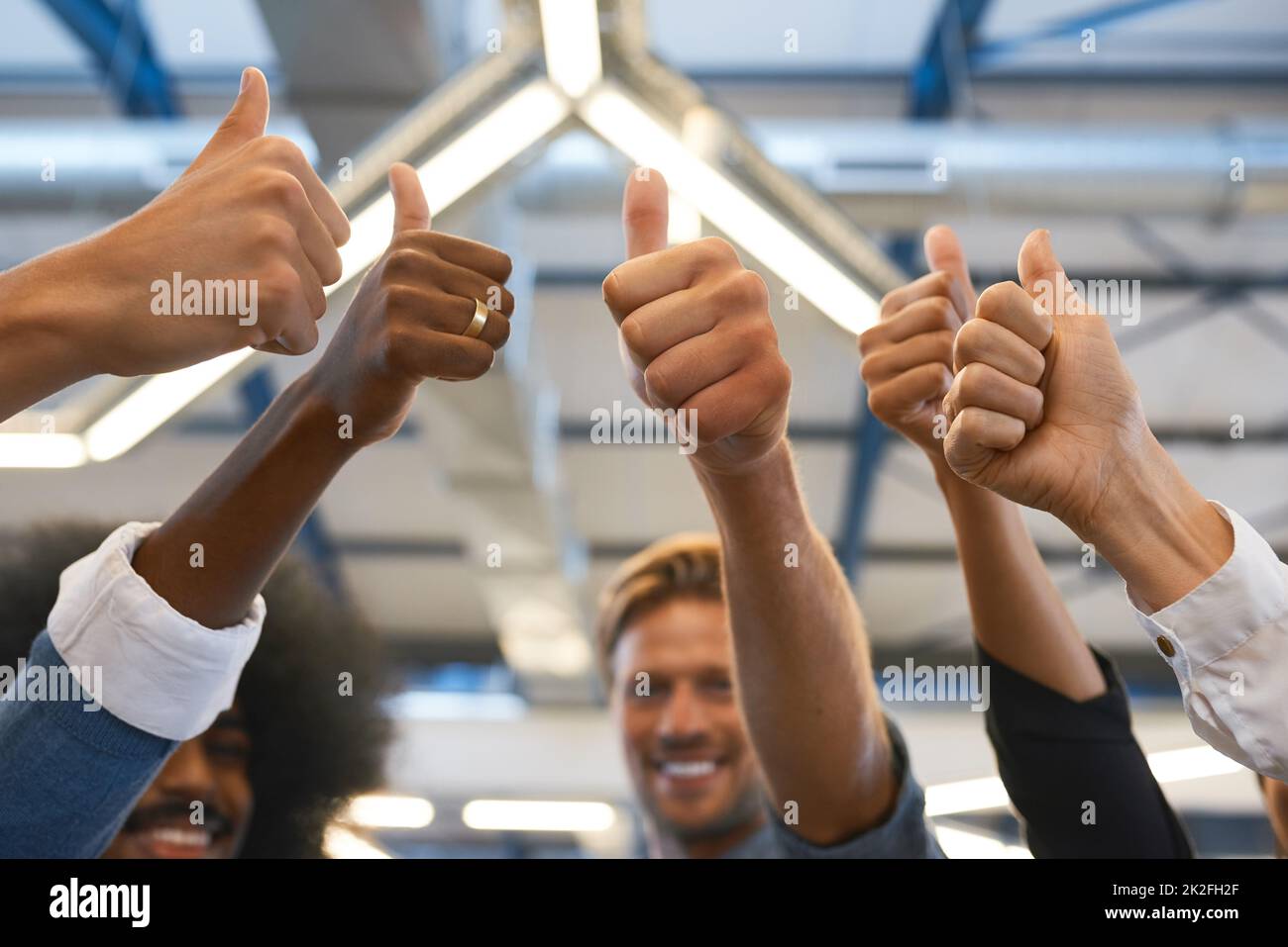 Youve got our approval. Cropped shot of a group of designers giving you the thumbs up in their ...