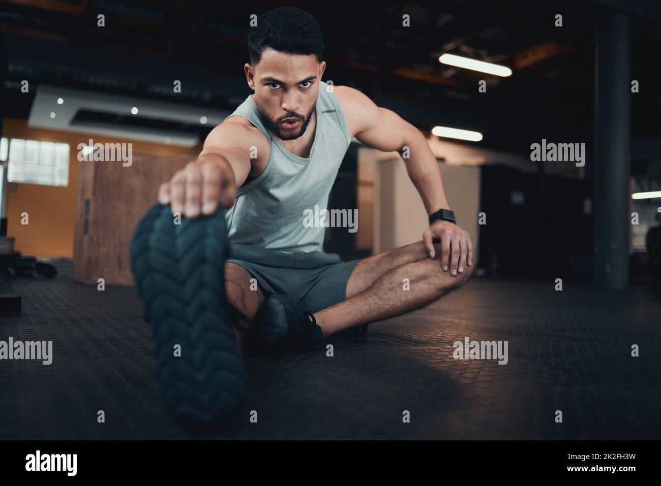 These calves need to be stretched. Shot of a young man stretching his ...
