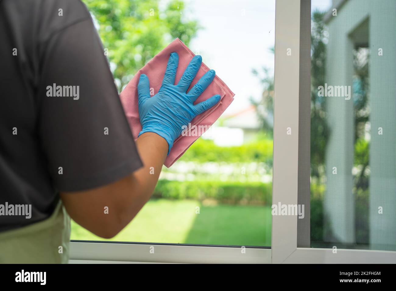 Maid cleaning wipe and wash the glass at widow in home Stock Photo - Alamy