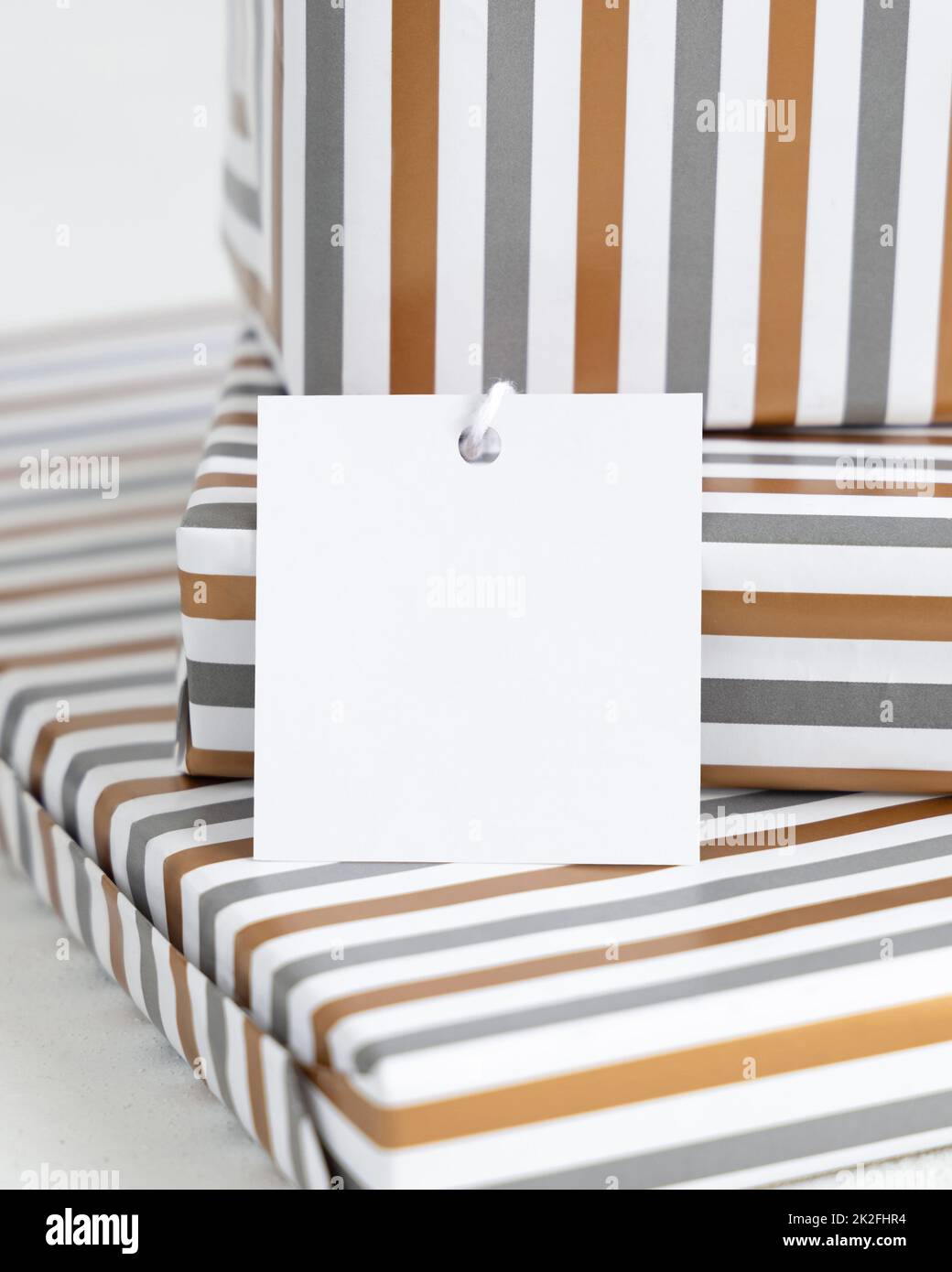 Presents Wrapped in striped paper with blank gift tag close up, label ...
