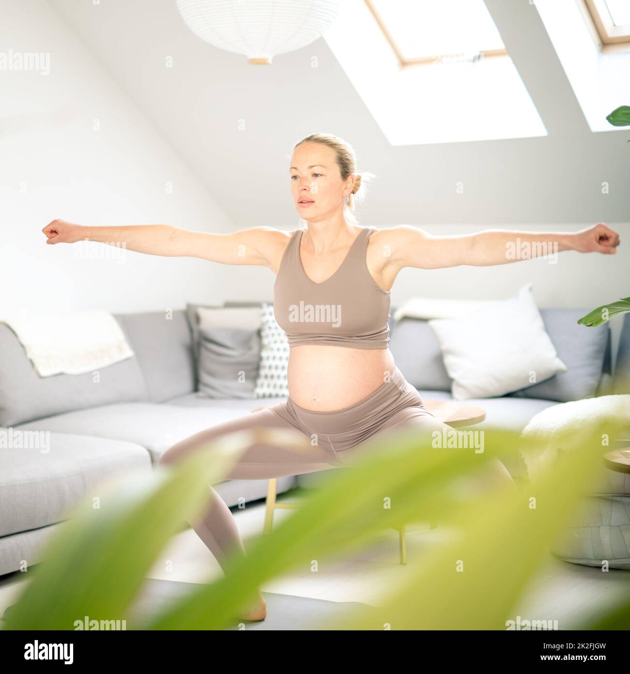Young beautiful pregnant woman training pilates at home in her living ...