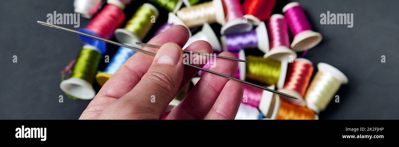classic sewing needle and threads in a tailor's hand,sewing needle ...