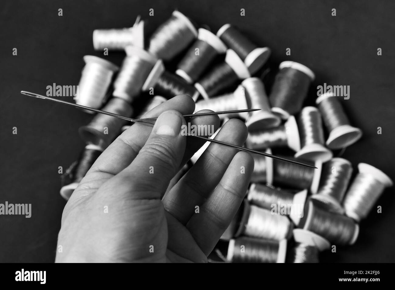 classic sewing needle and threads in a tailor's hand,sewing needle ...