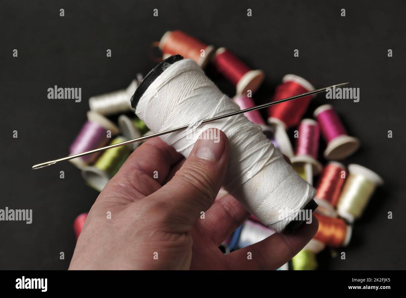 close-up there are lots of colorful spools of thread, thick sewing ...