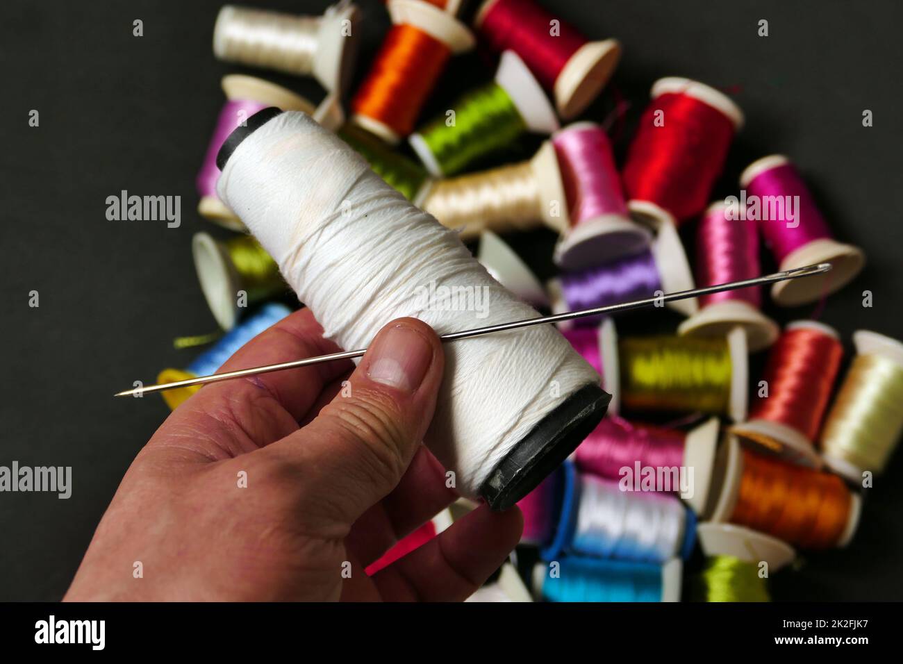 close-up there are lots of colorful spools of thread, thick sewing ...