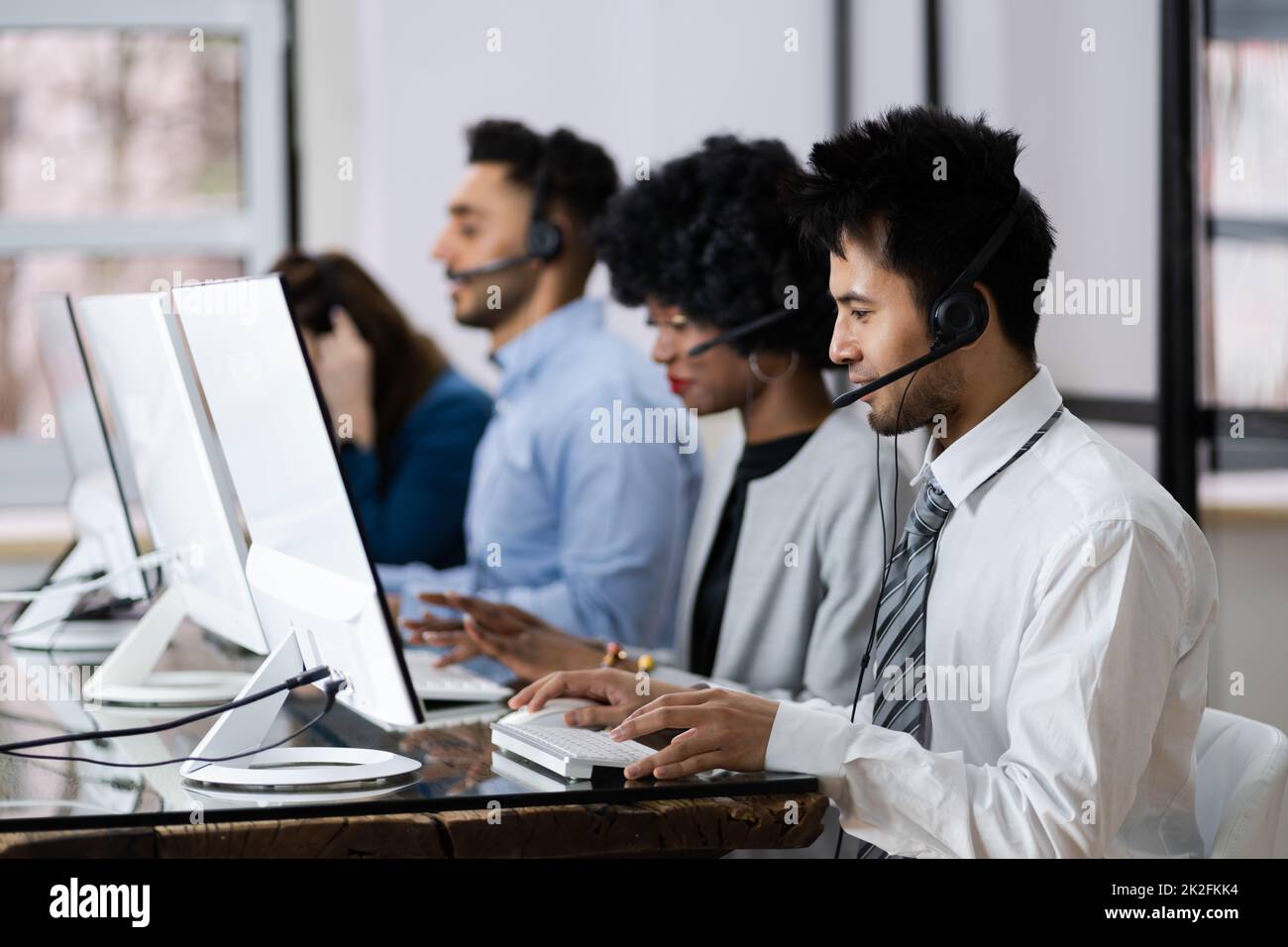 Positive Customer Services Agent With Headset Working Stock Photo - Alamy
